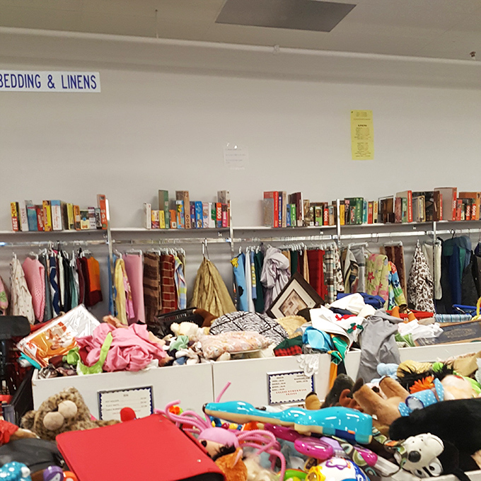 Bedding and linens share space with books, because apparently literature pairs perfectly with comfortable sleeping arrangements.
