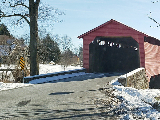 Winter transforms the bridge into something from a holiday card—the red exterior popping dramatically against pristine snow.