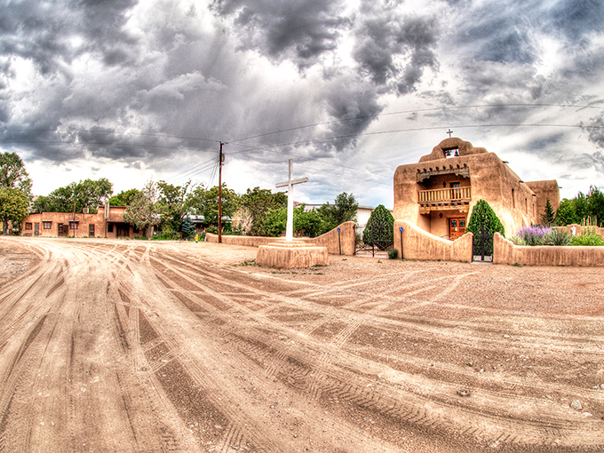 Abiqui&uacute;'s adobe church stands eternal against desert cliffs, a testament to faith and southwestern architectural beauty.
