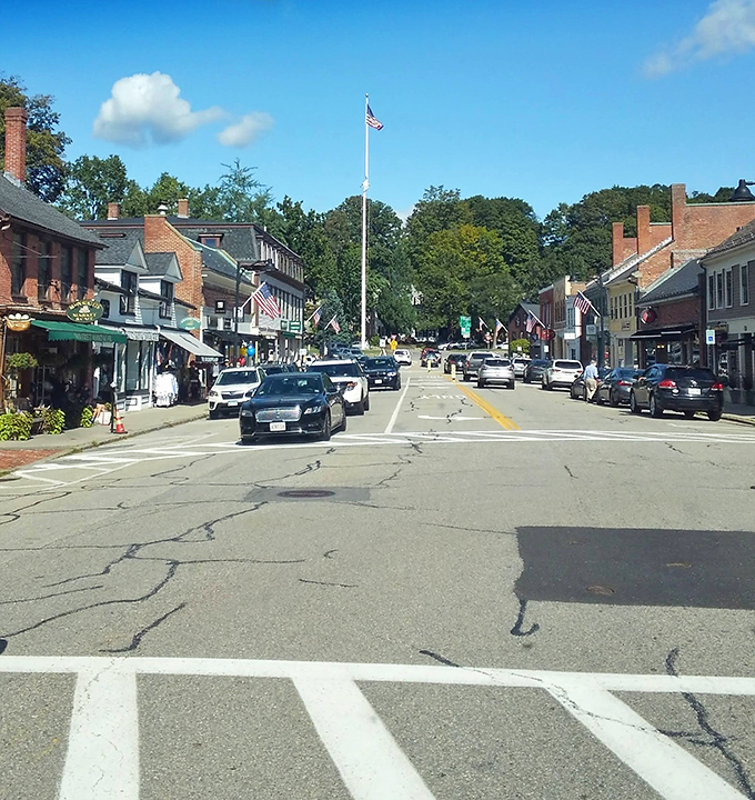 Concord's main street captures small-town America at its most authentic. The American flag stands tall, anchoring this classic New England scene.