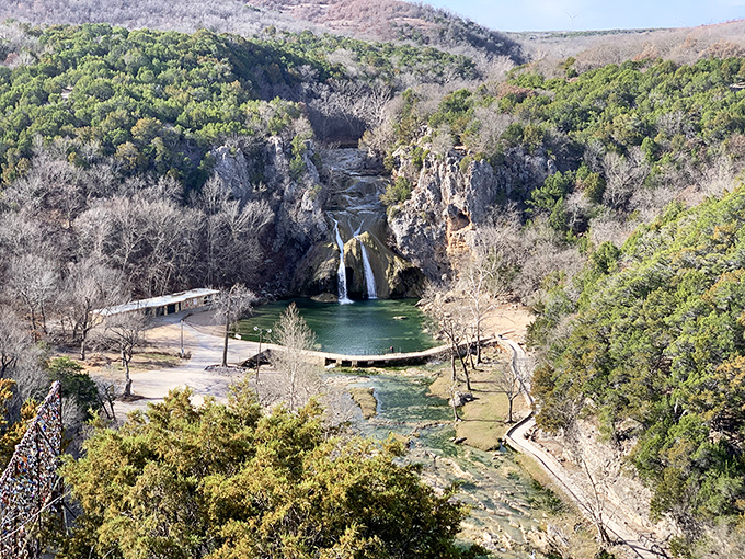 Turner Falls cascades 77 feet down limestone cliffs, creating Oklahoma's most spectacular natural swimming pool and scenic wonder.