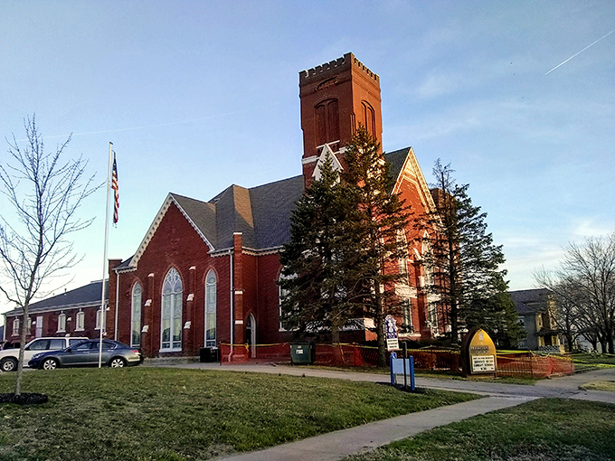 Historic red brick church in Fulton stands tall against the blue sky, a timeless landmark where community and faith have flourished for generations.