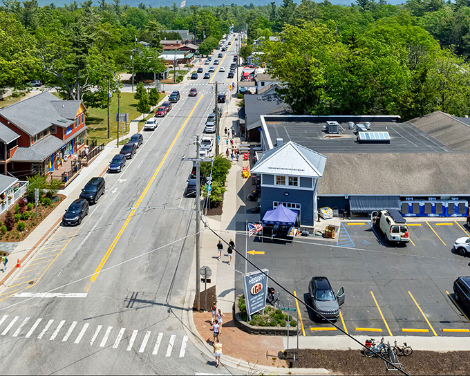 Main Street America stretches toward wooded hills, offering that perfect small-town rhythm where rush hour means three cars at the stoplight.