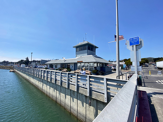 Half Moon Bay's harbor building stands sentinel at the edge of the pier, where fishing tales grow as long as the day's shadows.