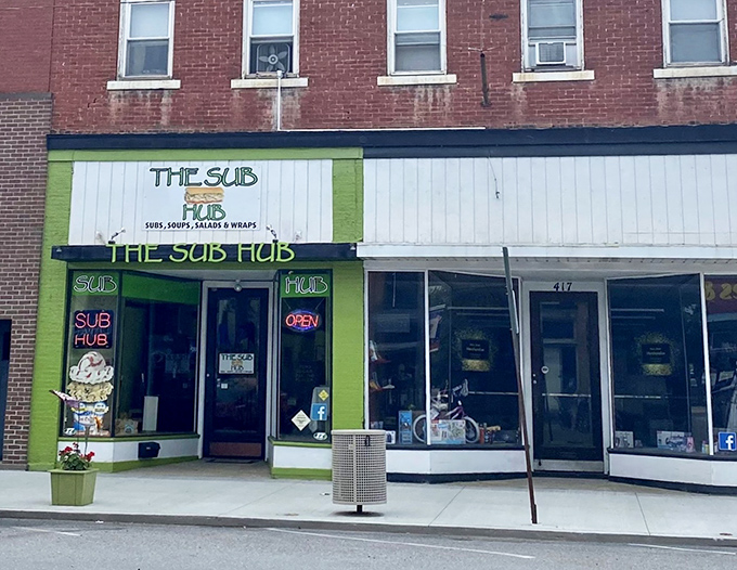 Bright green enthusiasm that proves the best hot dogs sometimes hide in unexpected sub shop corners.