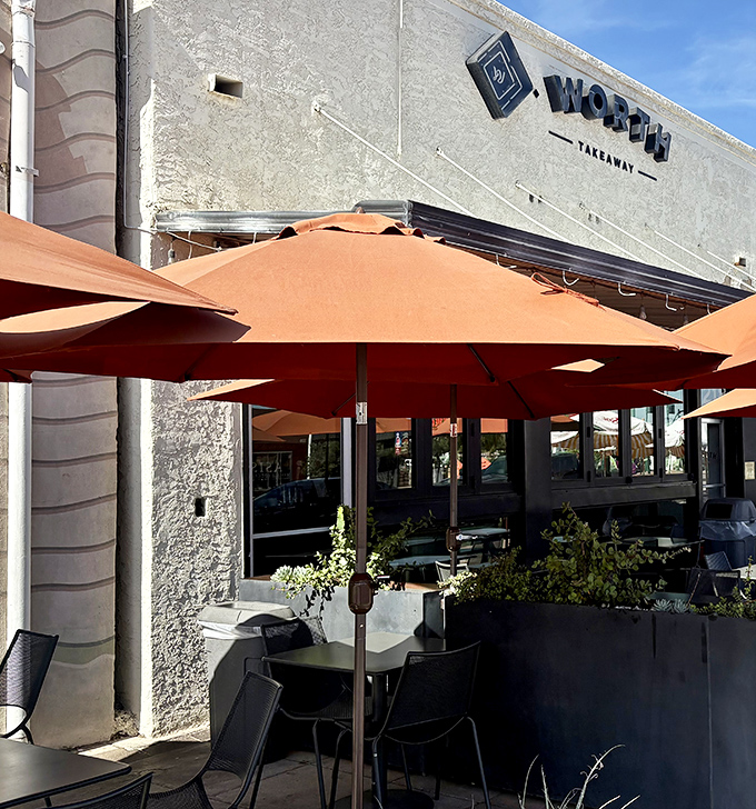 Those warm terracotta umbrellas provide shade while you savor sandwiches that are definitely worth sitting down for properly.