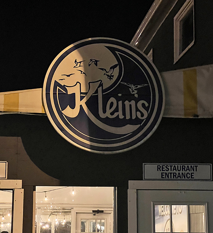 Moonlight and maritime meals! Klein's glowing sign beckons night owls to savor oceanic delights while seagulls dance across their iconic logo.
