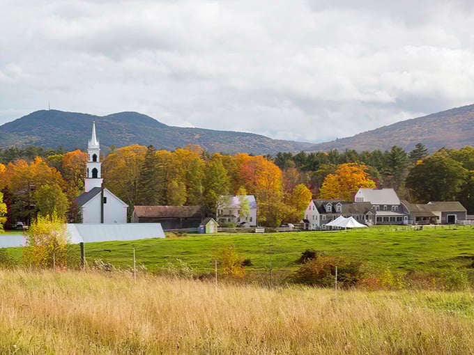 Tamworth's white church stands sentinel against rolling hills and autumn trees, a postcard-perfect scene that defines rural New Hampshire.