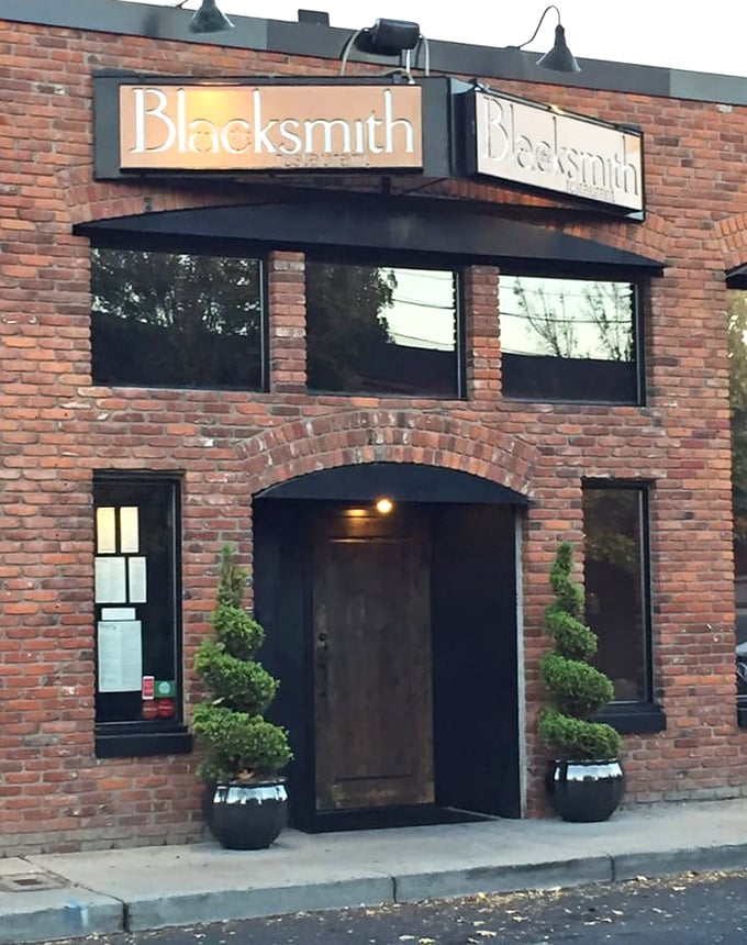 The Blacksmith's entrance, flanked by tidy topiaries, hints at the perfect balance of rustic history and refined dining inside.