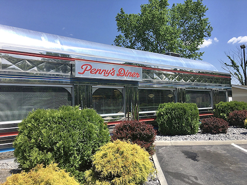 Penny's Diner gleams like a chrome time machine, promising comfort food classics that taste exactly like your fondest road trip memories.