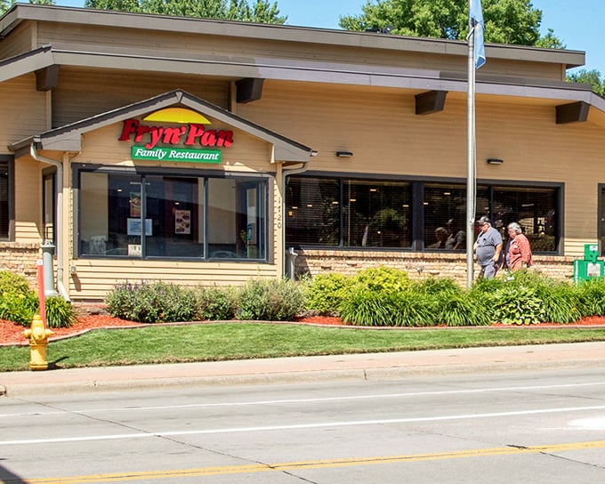 The Fryn' Pan's welcoming exterior promises comfort food salvation with its distinctive peaked roof and cheerful landscaping. Like a beacon for the breakfast-deprived traveler.
