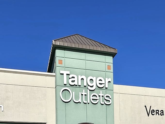 The iconic mint-green tower of Tanger Outlets stands against a perfect Ozark blue sky, like a beacon calling to bargain hunters everywhere.