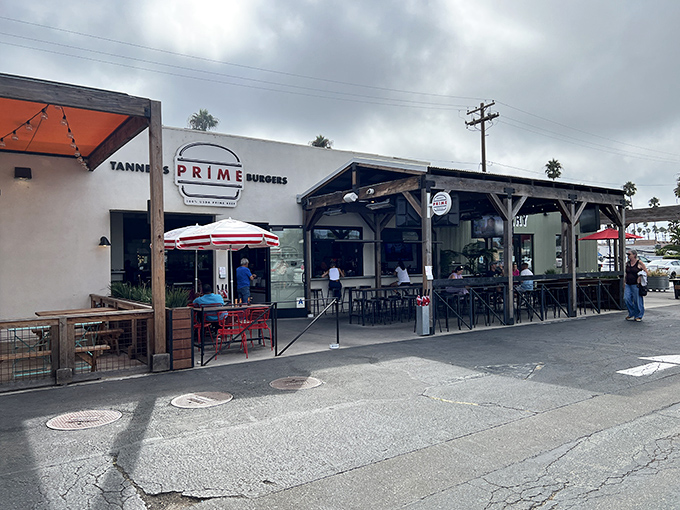 The unassuming exterior of Tanner's Prime Burgers belies the culinary magic happening inside. Palm trees and patio seating hint at the laid-back SoCal vibe.