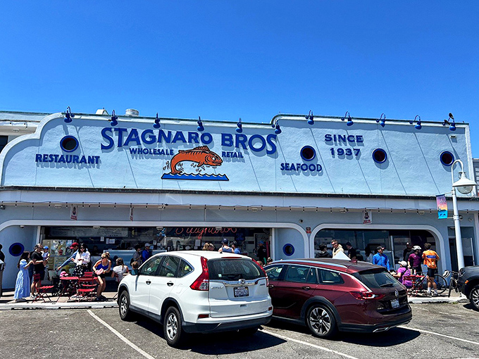 The iconic white and blue facade of Stagnaro Bros. welcomes hungry visitors with its cheerful fish logo and promise of seafood treasures within.