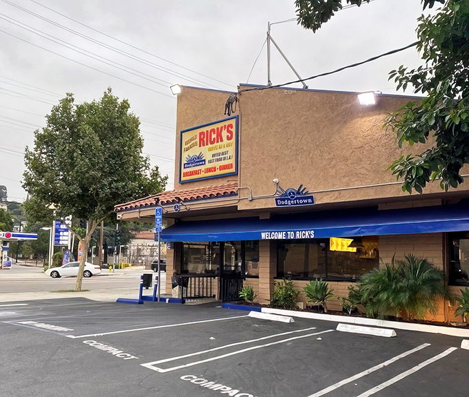 Rick's iconic stucco exterior stands like a culinary lighthouse on Riverside Drive, beckoning hungry travelers with its blue awning and timeless charm.