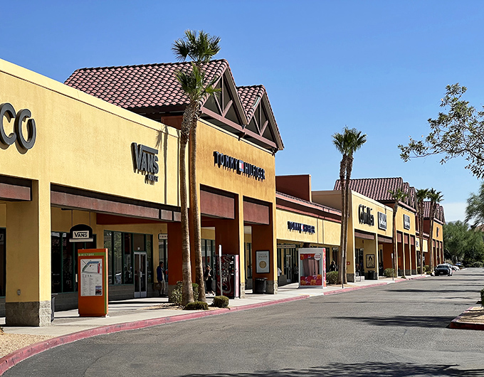 Spanish-style architecture meets desert bargain hunting. Palm trees stand guard over the Guess storefront like sentinels of savings.