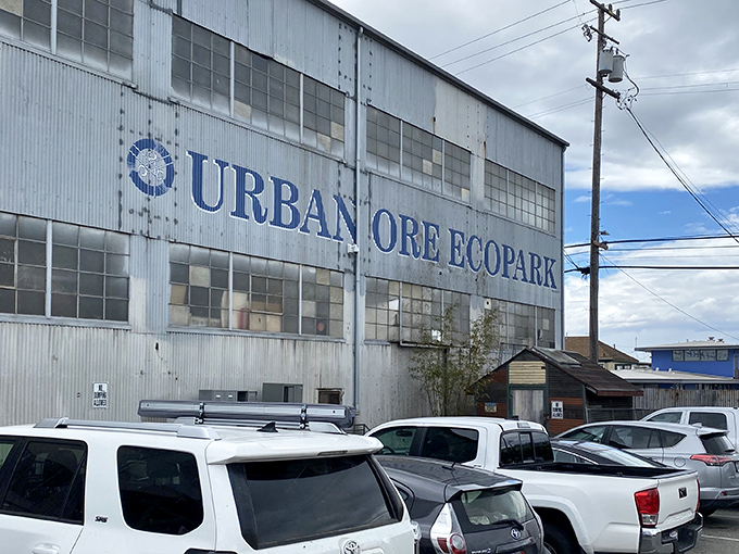 The corrugated metal exterior of Urban Ore Ecopark stands like a cathedral of castoffs, beckoning treasure hunters with its blue lettering and promise of wonders within.