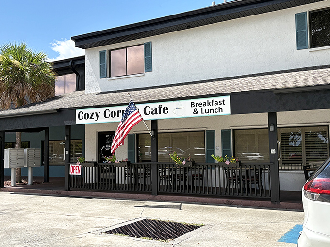The classic Florida welcome: white stucco, American flag, and an "OPEN" sign that might as well say "Breakfast Paradise Awaits."