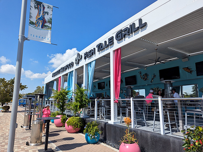 The pristine white exterior of Fish Tale Grill beckons like a culinary lighthouse on Cape Coral's shoreline, complete with colorful planters that say "Yes, vacation starts here."