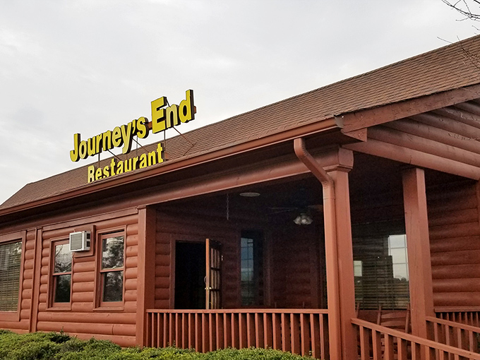 The rustic log cabin exterior of Journey's End Restaurant stands as a beacon of comfort food promise in Loganville, its yellow sign a lighthouse for hungry travelers.
