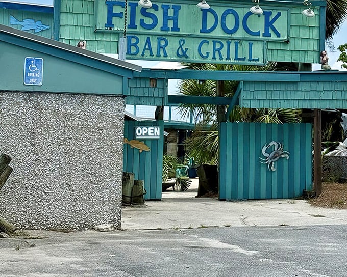 The turquoise beacon of seafood salvation! The Fish Dock's weathered exterior and wooden crab decoration promise authentic coastal delights within.