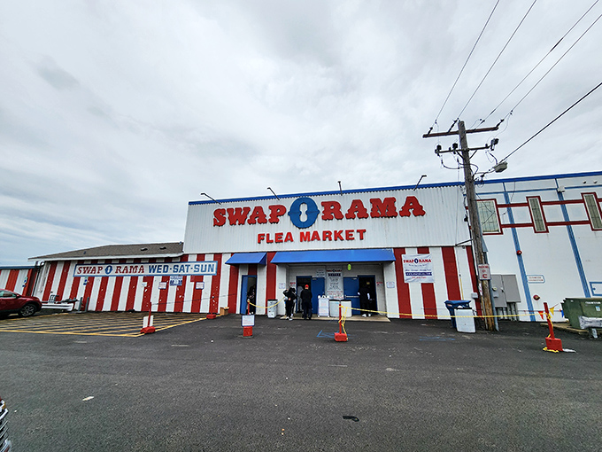 The red and white exterior of Swap-O-Rama beckons like a carnival of commerce, promising treasures waiting to be discovered inside.