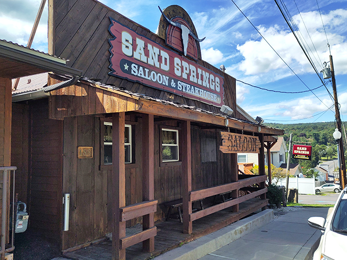 The iconic wooden facade and cattle skull sign of Sand Springs Saloon & Steakhouse welcomes hungry travelers like a frontier outpost for modern appetites.