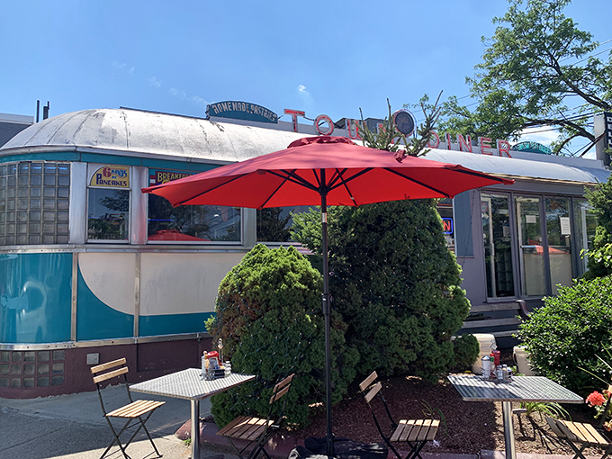Evergreen shrubs stand guard outside this stainless steel sanctuary, where pancake dreams come true regardless of season.