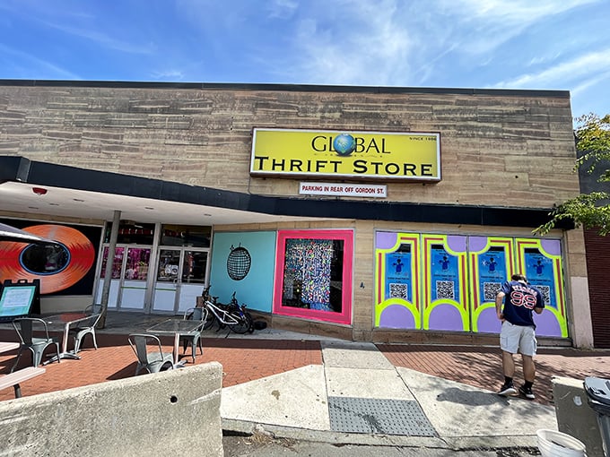 The vibrant facade of Global Thrift beckons with its colorful murals and retro signage – a siren call to treasure hunters throughout Massachusetts.