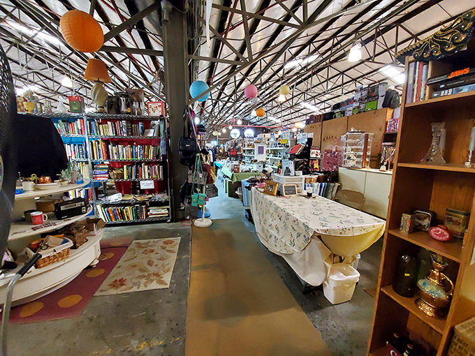 Colorful balloons hang above a maze of vendor stalls, where books and treasures await discovery in the sprawling market space.