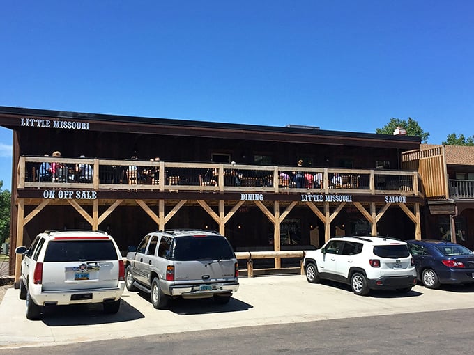 The Little Missouri Saloon stands proudly in Medora, its rustic wooden facade and balcony beckoning hungry travelers like a frontier oasis in the Badlands.