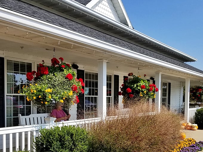 The welcoming front porch at Berlin Farmstead, where hanging flower baskets and rocking chairs invite you to slow down before the feast begins.
