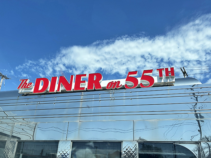 The gleaming stainless steel exterior of Diner on 55th shines like a time machine to the golden age of roadside dining. That red signage practically screams "good food ahead!"