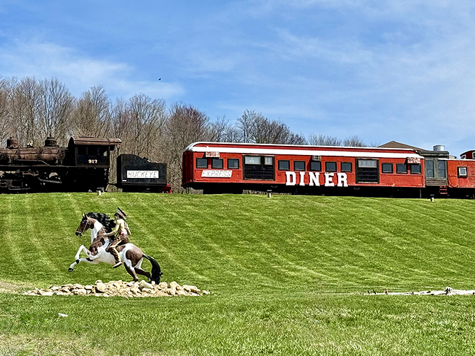 All aboard the flavor express! The bright red Buckeye Express Diner sits majestically on a grassy hill, with a vintage locomotive keeping it company.