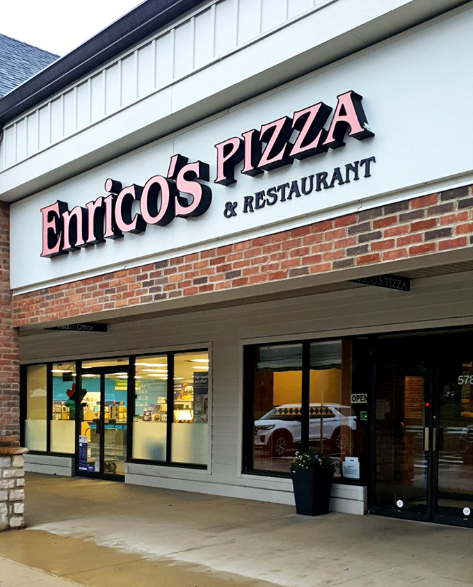 The iconic lettering of Enrico's Pizza & Restaurant beckons from its humble strip mall home, proving extraordinary flavors often hide in ordinary places.