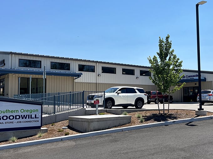 The modern exterior of Southern Oregon Goodwill stands ready to welcome treasure hunters, its clean lines and spacious parking lot promising adventures in secondhand shopping.
