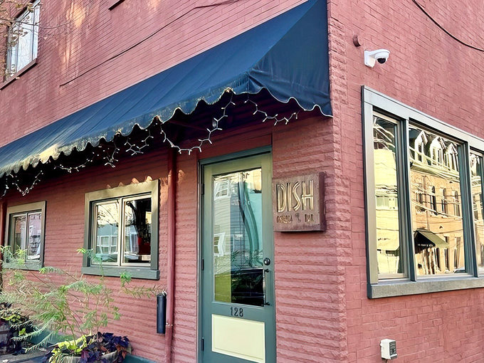 That coral-pink brick exterior whispers "neighborhood gem" while the scalloped awning practically winks at passersby.