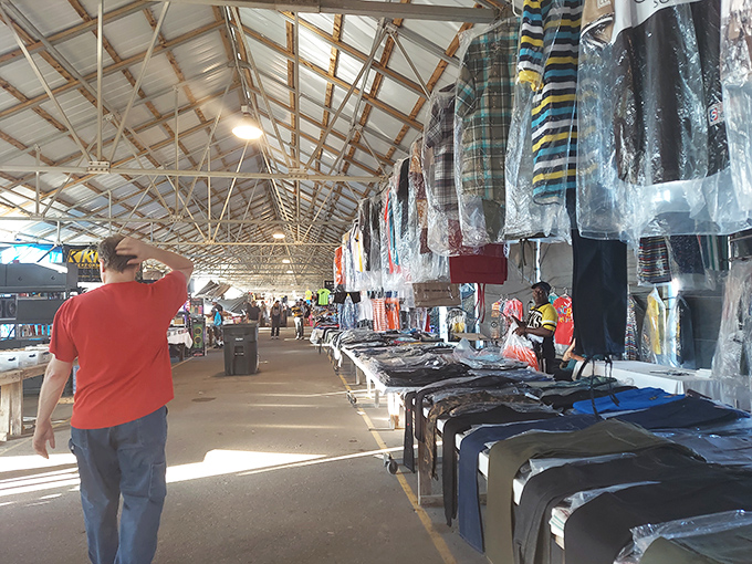 Sunlight streams through the high ceilings, illuminating a treasure hunter's paradise where clothing vendors display their wares like modern-day merchants.