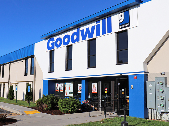 The blue-and-white facade of Goodwill Williston stands like a beacon of bargain possibilities under Vermont's clear skies.