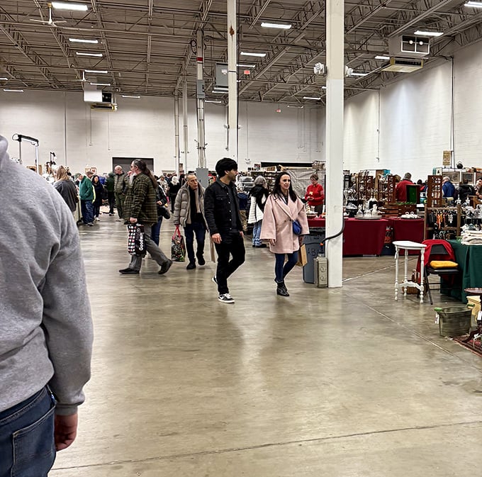 The spacious interior of The Big Flea Market buzzes with treasure hunters navigating a maze of vendor booths under bright industrial lighting.