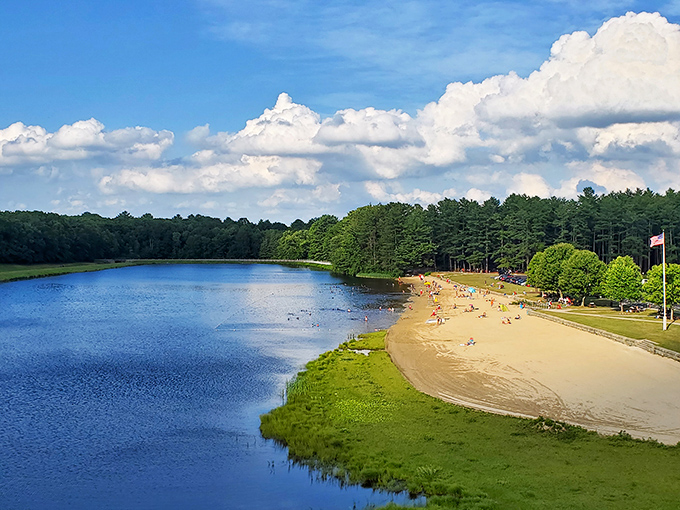 The golden sandy beach curves along Hopkinton Reservoir like nature's perfect smile, inviting visitors to dip their toes or dive right in.