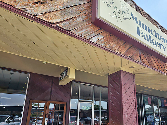 The unassuming wooden exterior of Munchers Bakery &ndash; where culinary magic hides behind modest architecture, like finding a Picasso in your grandma's attic.