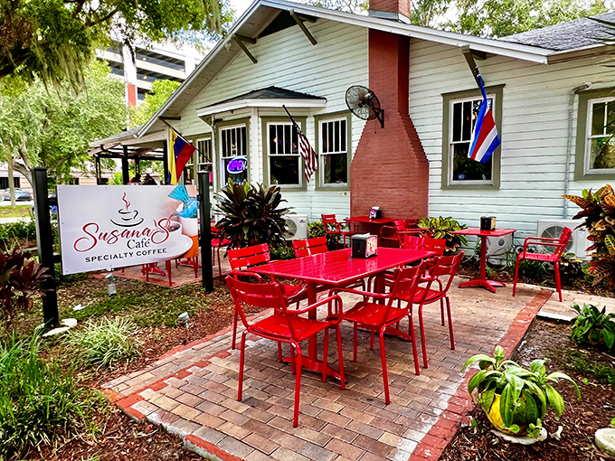A charming white cottage with eye-catching red outdoor furniture beckons under Florida shade trees. Susana's Cafe feels like a secret you can't wait to share.