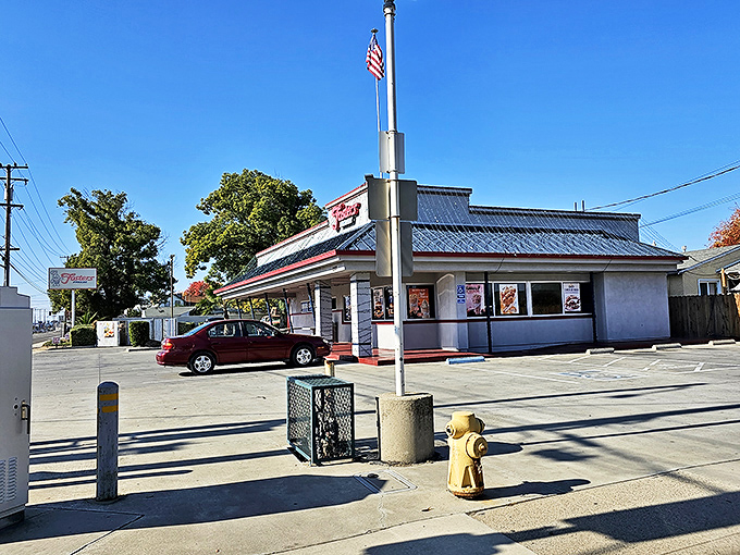 Another angle reveals the drive-in's timeless architecture, complete with an American flag waving proudly above this temple of comfort food.