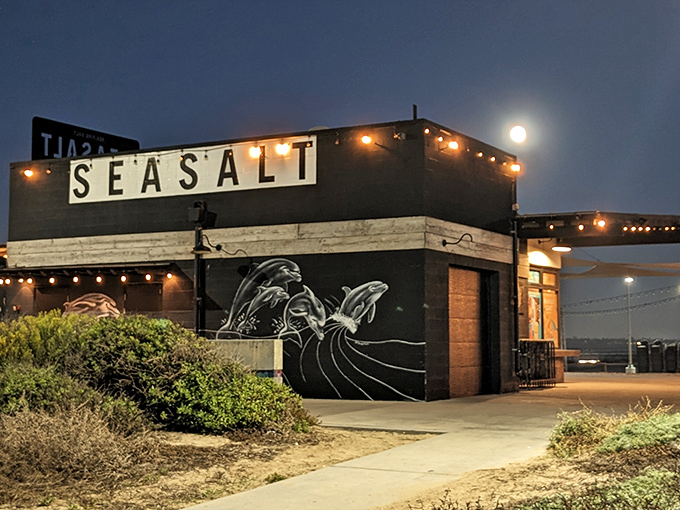 The nighttime glow of Sea Salt transforms this beachside eatery into a magical dining destination where ocean waves provide the soundtrack to your meal.