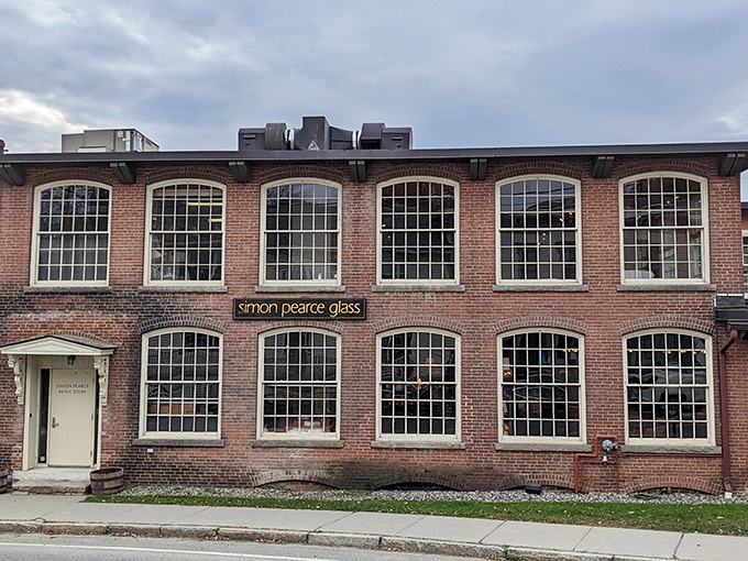 The historic brick fa&ccedil;ade of Simon Pearce stands proudly in Quechee, where artisanal glass and culinary magic have shared a home for decades.