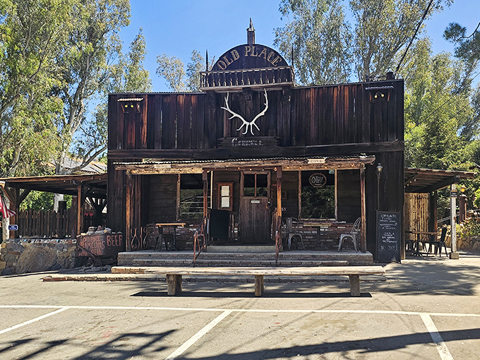 The Old Place stands proudly against the California sky, its weathered wooden facade and antler decoration announcing: "Yes, time travel is possible."