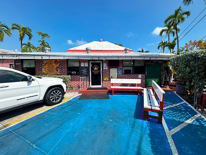 Palm trees stand guard outside this Key West institution. The blue concrete patio and red benches hint at the colorful flavors waiting inside.