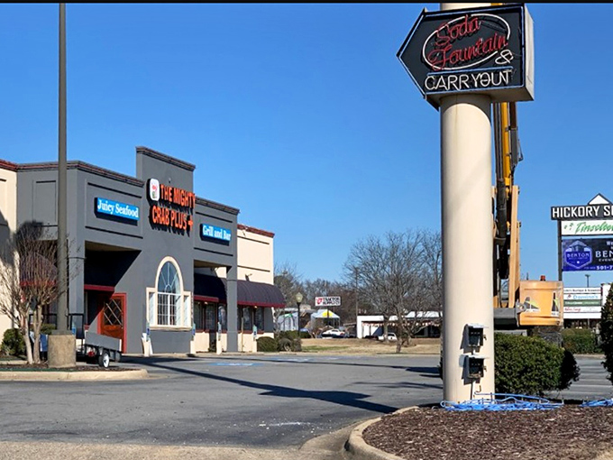 The Mighty Crab announces its presence with bold red signage, standing proudly in a Benton shopping center like a beacon for seafood lovers seeking their next great meal.