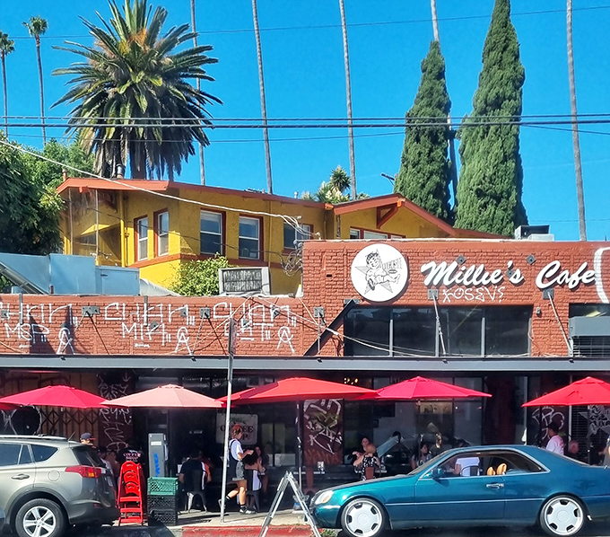 Millie's Cafe stands proud with its vibrant yellow and red exterior, where palm trees and California sunshine create the perfect backdrop for comfort food paradise.